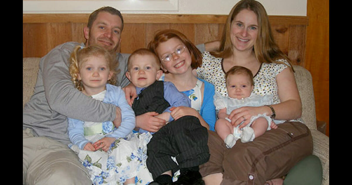 Koko perhe poseeraa iloisina yhdessä sohvalla – kuvaan tallentui ...